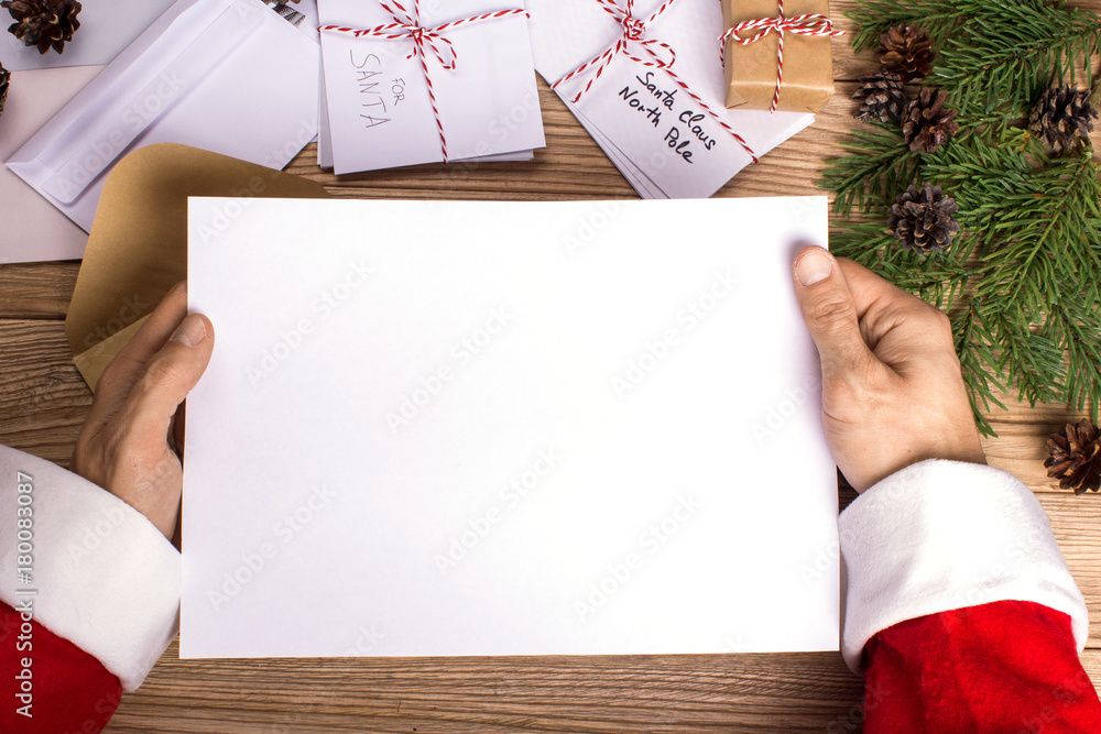 Santa Claus reads letters and holds them in his hands. Mock-up letter ...