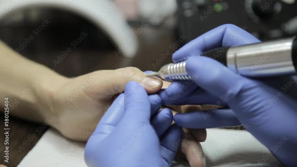 Receiving cuticle removing procedure with nail tools in nails saloon ...