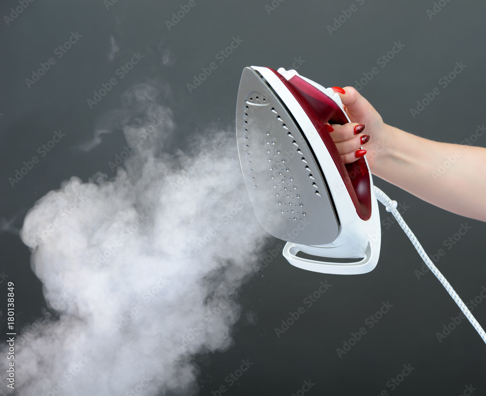 Iron with steam on dark grey background Stock Photo | Adobe Stock