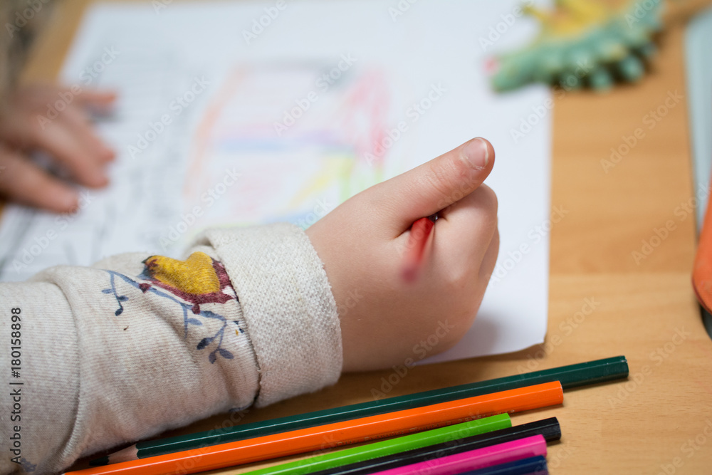 Kind malt und bastelt mit Buntstiften und Schere Stock Photo | Adobe Stock