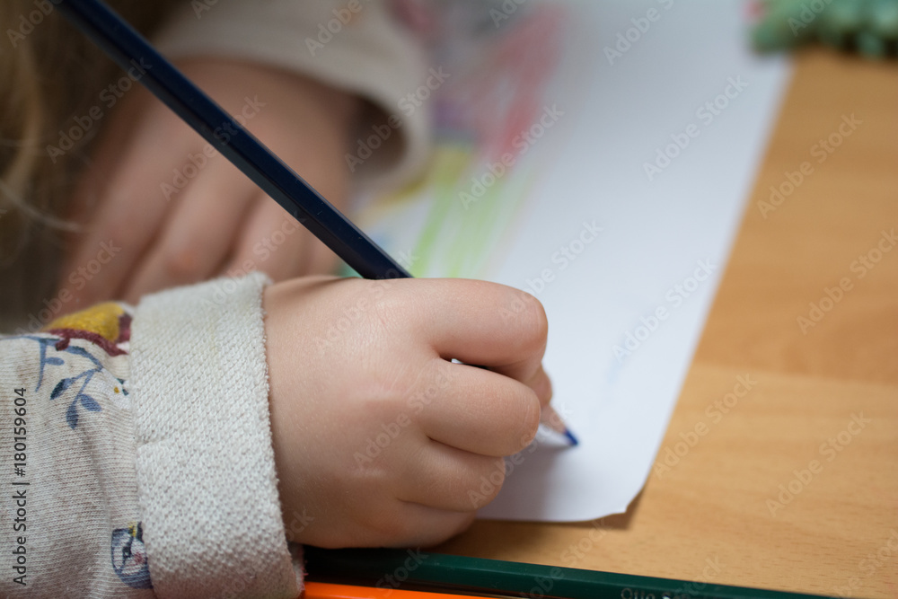 Kind malt und bastelt mit Buntstiften und Schere in Schule,Kindergarten ...