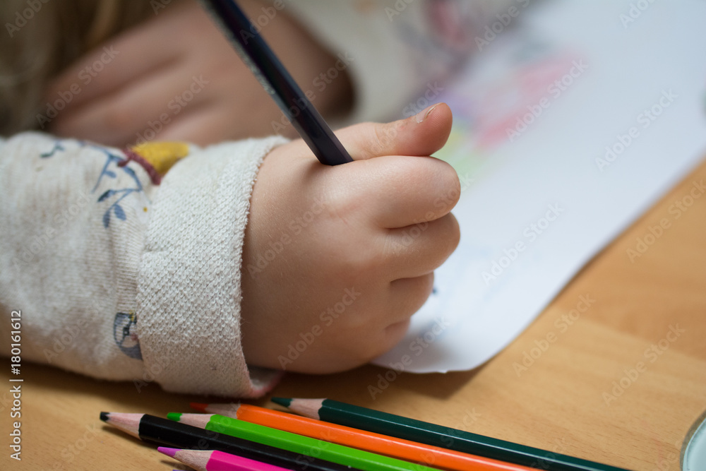 Kind malt und bastelt mit Buntstiften und Schere Stock Photo | Adobe Stock