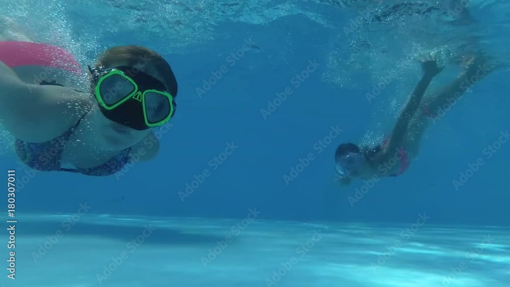 Happy smiling underwater girls swim in swimming pool, beautiful healthy ...