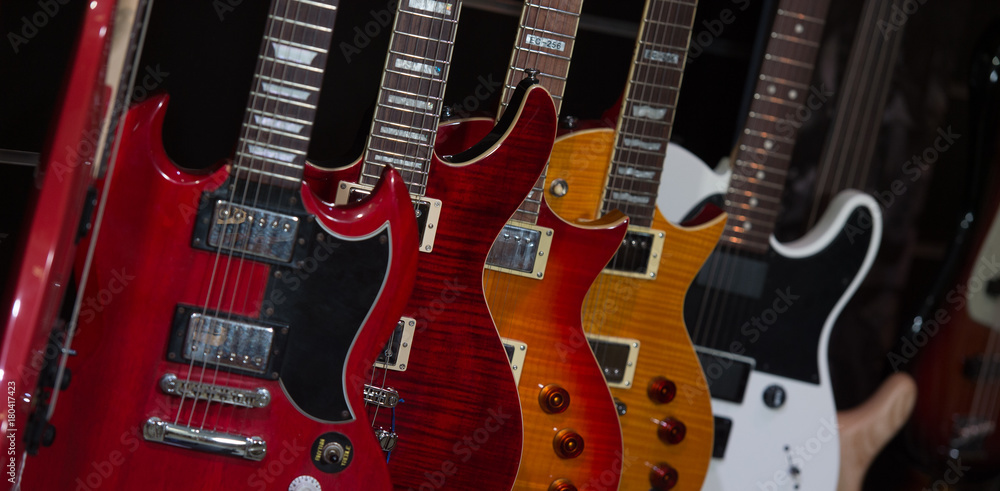 Many electric guitars hanging on wall in the shop Stock Photo | Adobe Stock