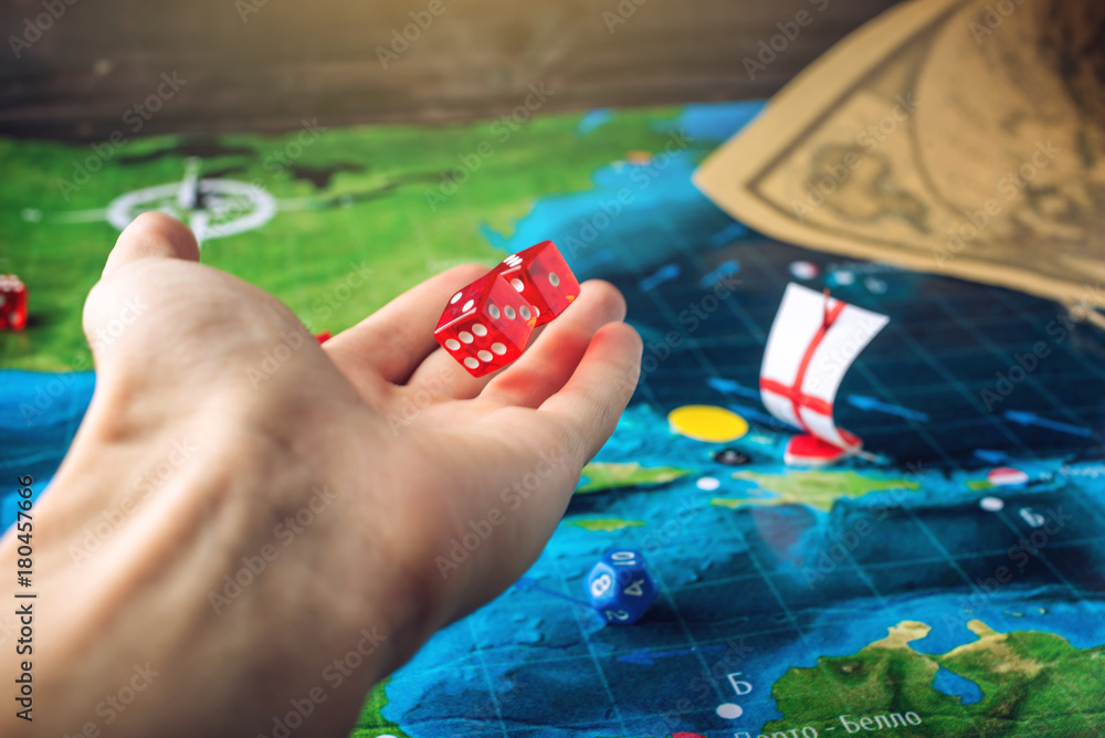 Hand throwing red dice on the world map of the playing field handmade ...