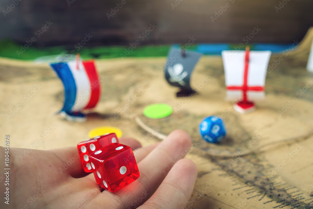 Hand throwing red dice on the world map of the playing field handmade ...