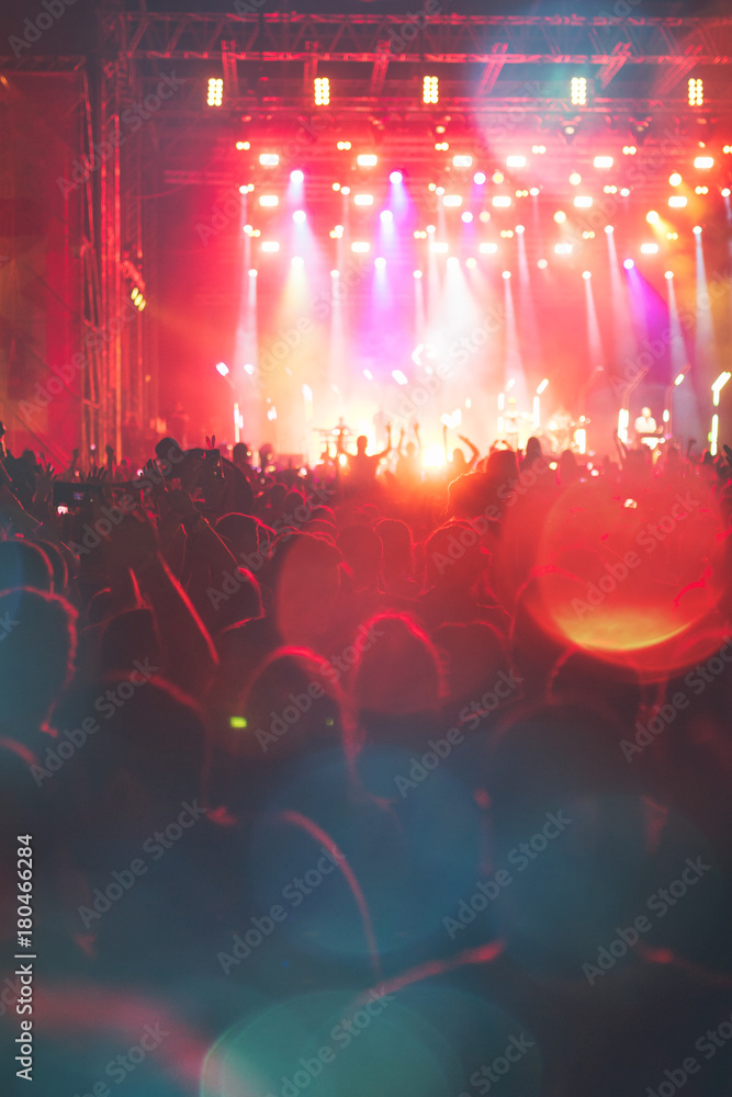 Silhouettes of festival concert crowd in front of bright stage lights ...