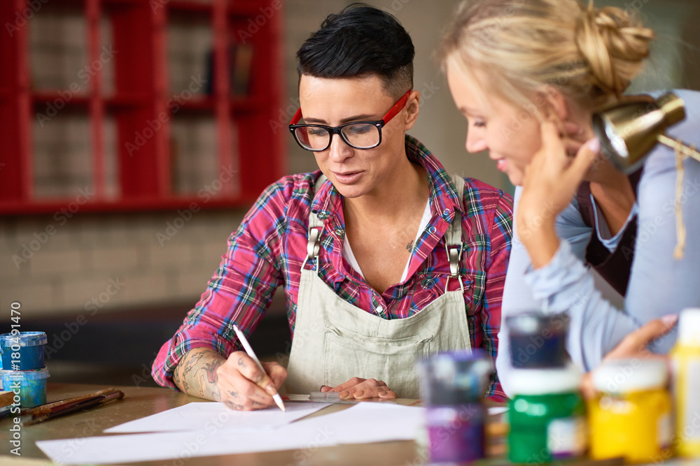 Portrait of two modern female artists enjoying working together in art ...