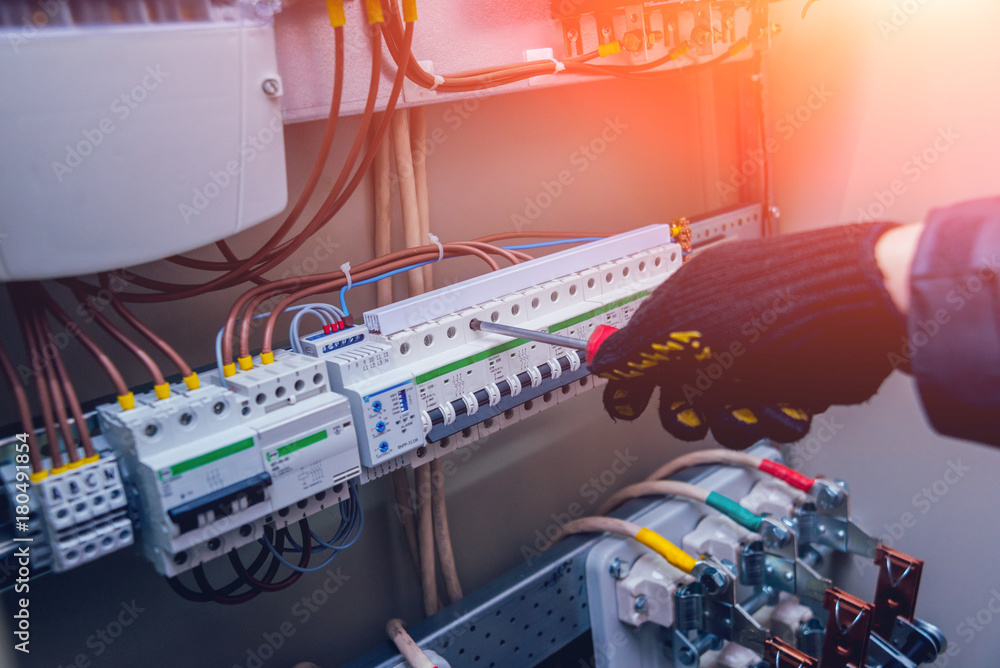 Electricians hands testing switches in electric box. Electrical panel ...