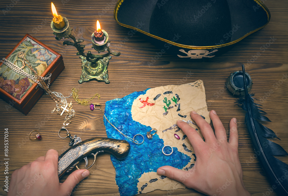 Crumpled treasure map and pirate hat on wooden table. Treasure hunt ...