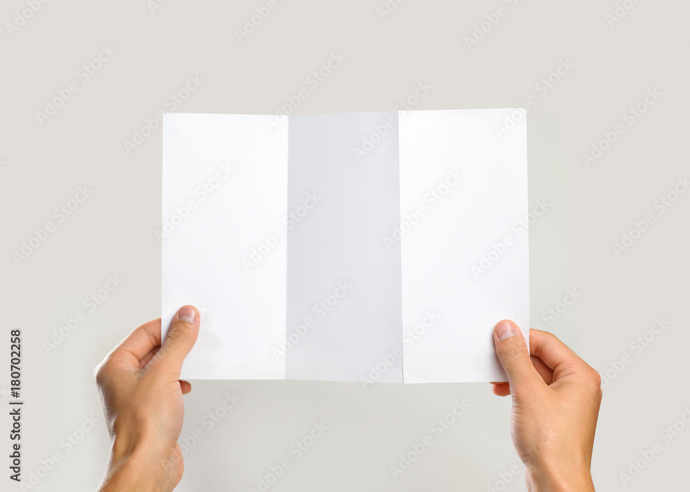 Hands holding blank brochure booklet in the hand. Leaflet presentation ...
