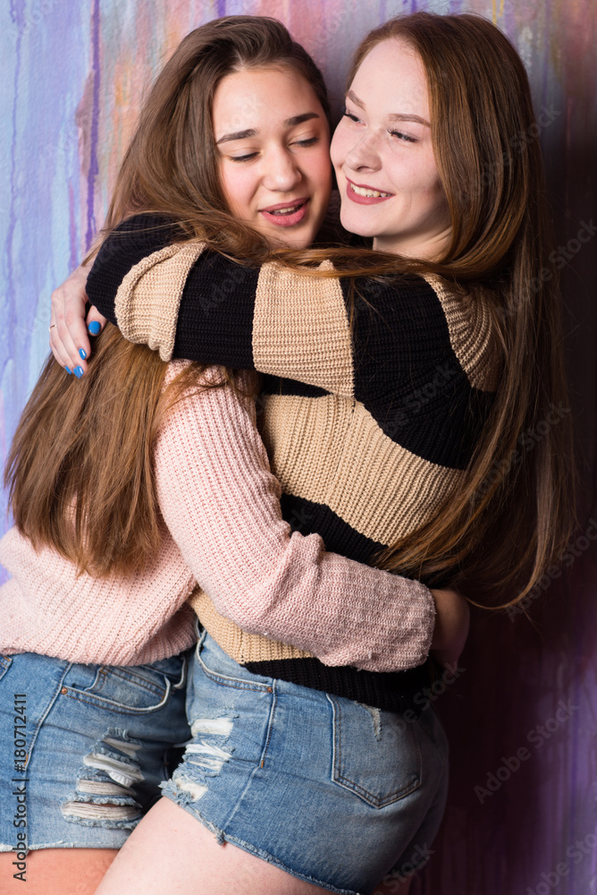 Half length of couple teenage girls hugging and having fun at painted ...