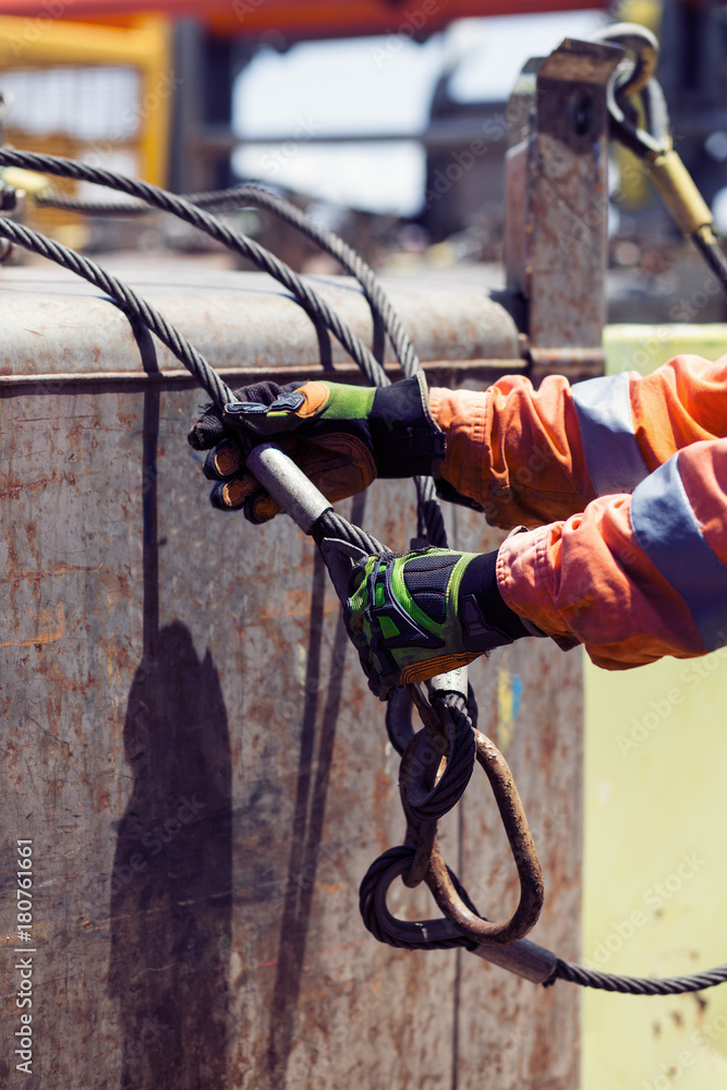 Hard job of able seaman on offshore vessel. He is connecting sling ...