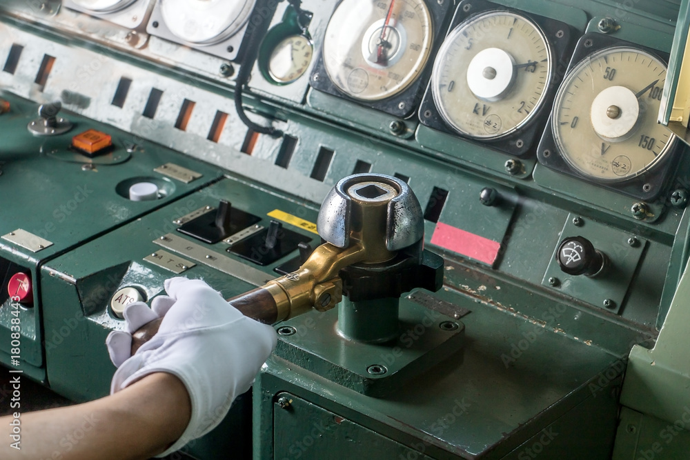 Hand in white gloves of Japanese rail driver check joystick in cab of ...