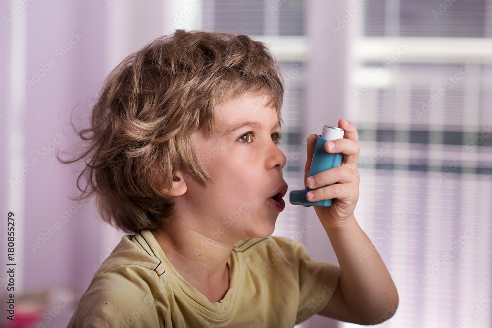 Boy using asthma inhaler to treat inflammatory disease, wheezing ...