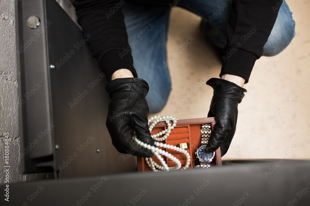 thief stealing valuables from safe at crime scene Stock Photo | Adobe Stock