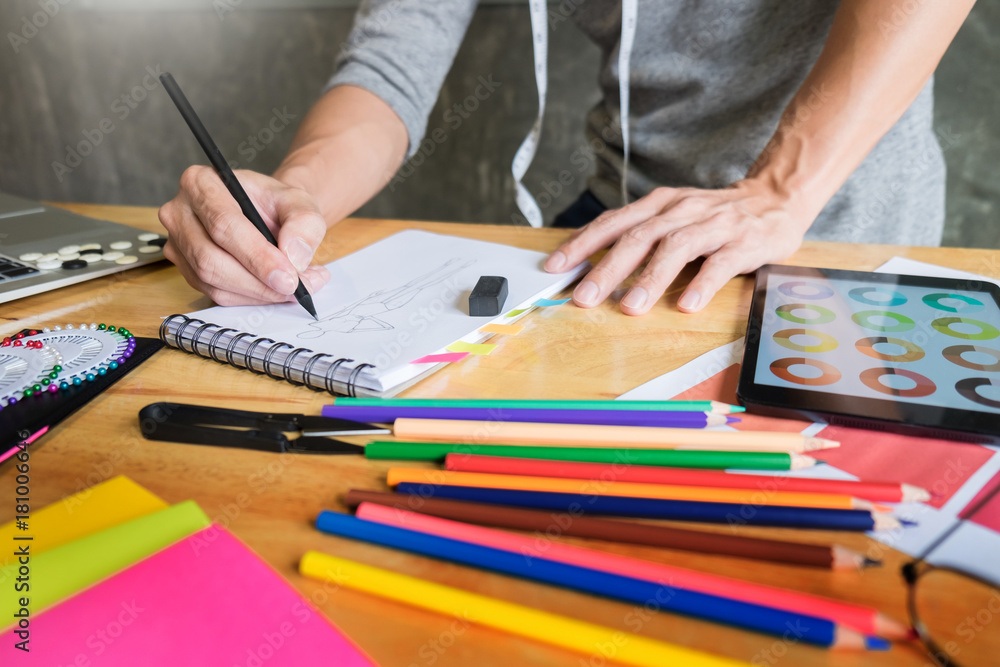 men working as fashion designer drawing sketches for clothes in atelier ...