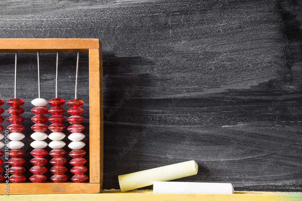 Old abacus with chalks at the blackboard in school. Mathematics lesson ...