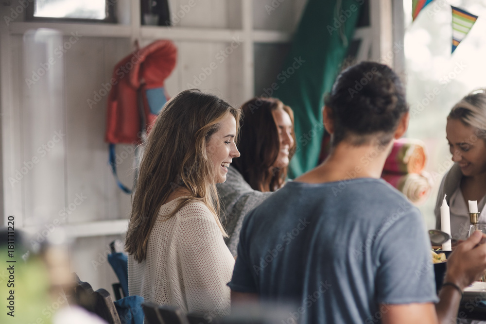 Happy young friends sitting at dining table Stock Photo | Adobe Stock