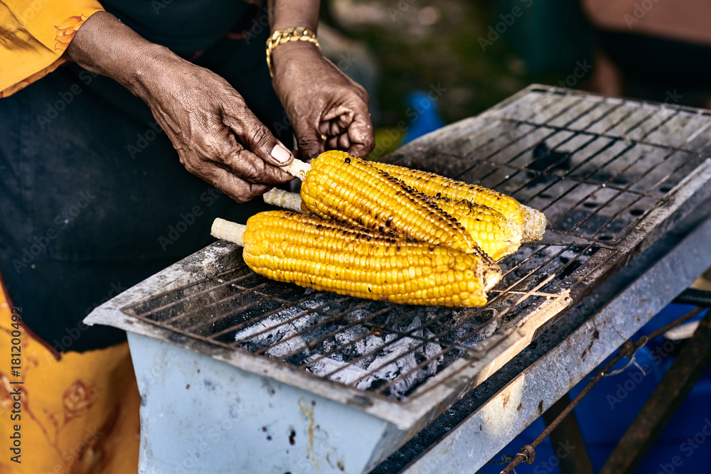 O ld rural asian woman cooked corn cobs on the grill. Close up image ...