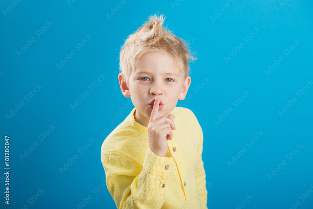 Cute boy doing silence gesture on studio background. Stock Photo ...