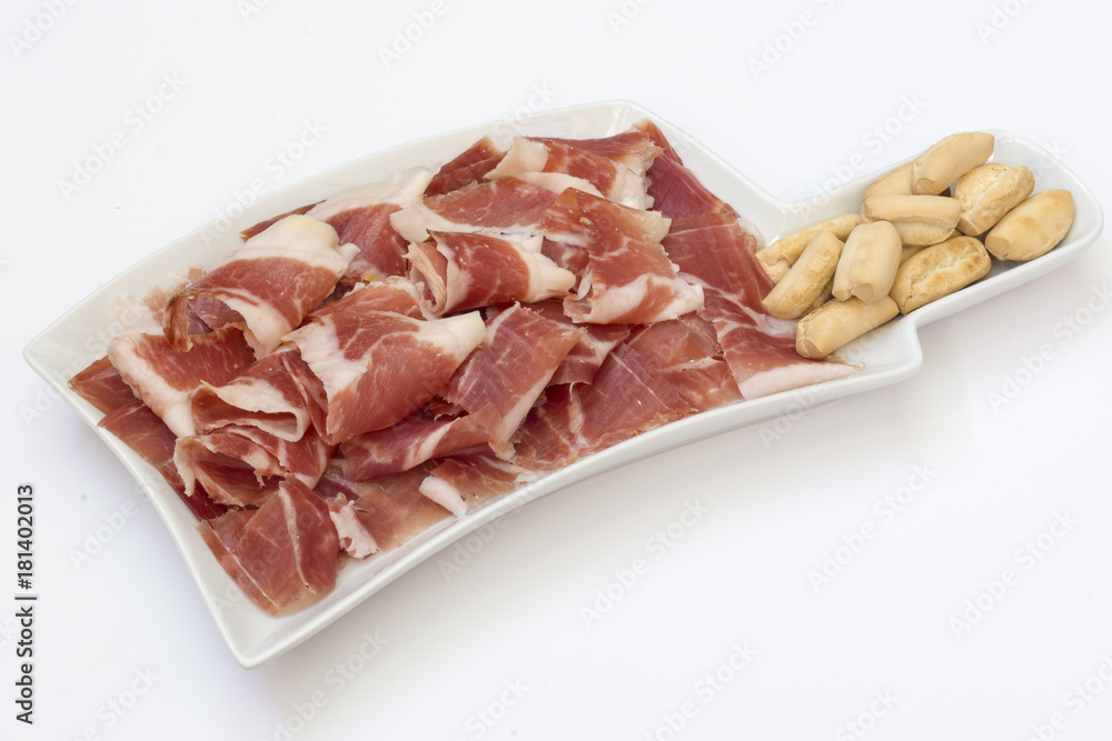 Un plato con lonchas de jamón y picos de pan, sobre fondo blanco Stock ...