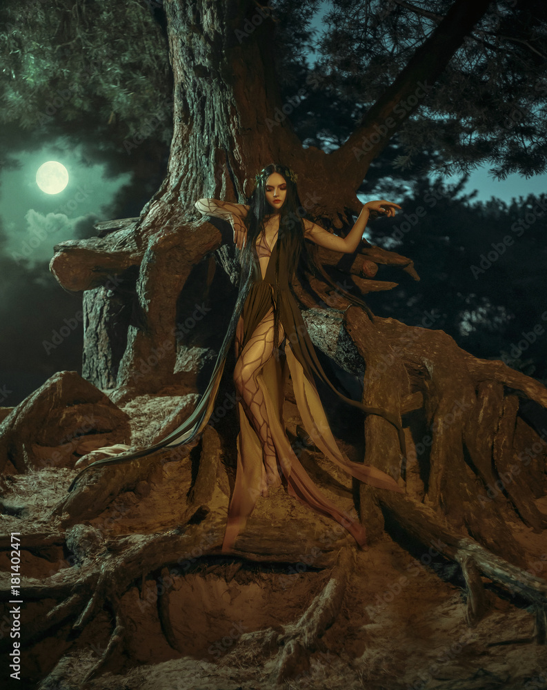 A fabulous, forest nymph with long hair lies on a tree branch with an ...