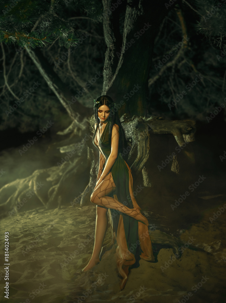 A fabulous, forest nymph with long hair lies on a tree branch with an aggressive look ...