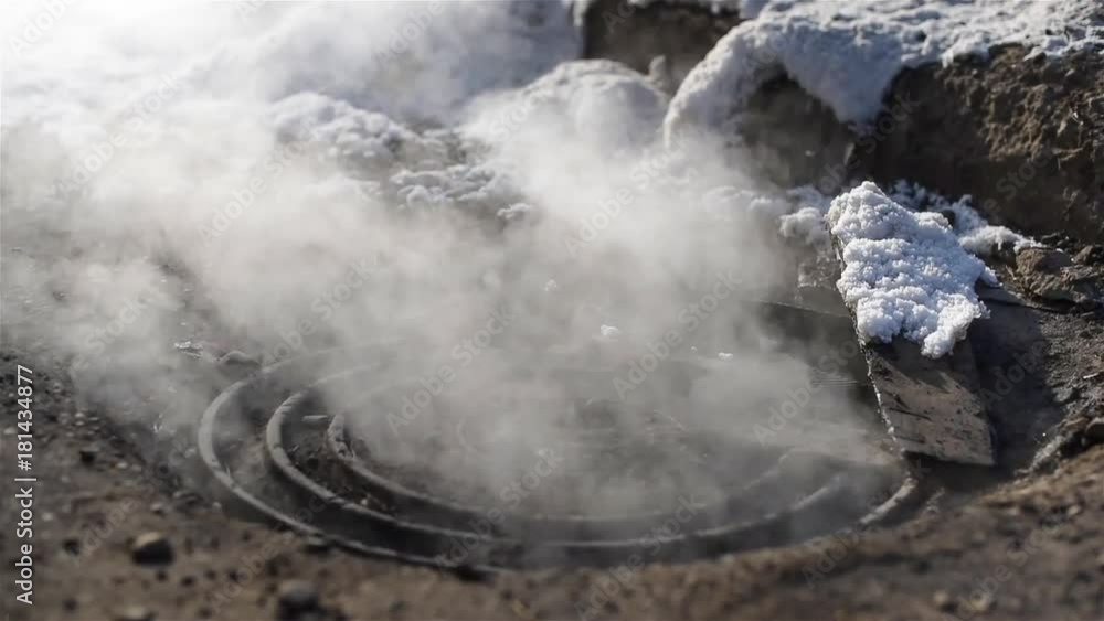 Steam leaves the sewer hatch Stock Video | Adobe Stock