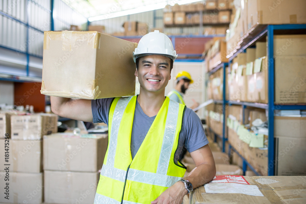 Warehouse worker holding package. Stock Photo | Adobe Stock
