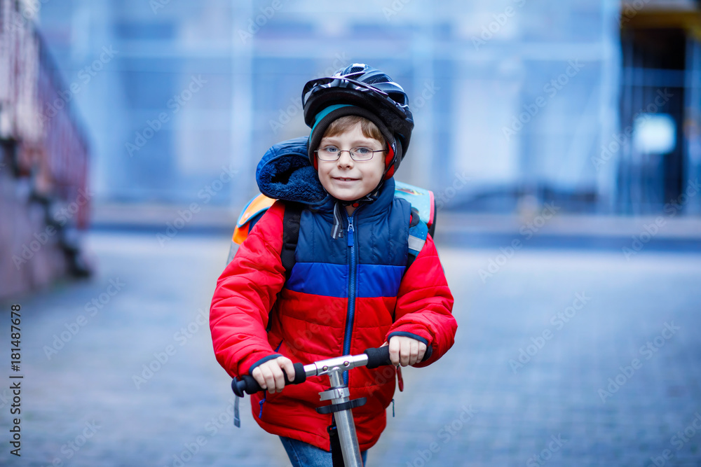 Cute little kid boy riding on scooter on way to school Stock Photo ...