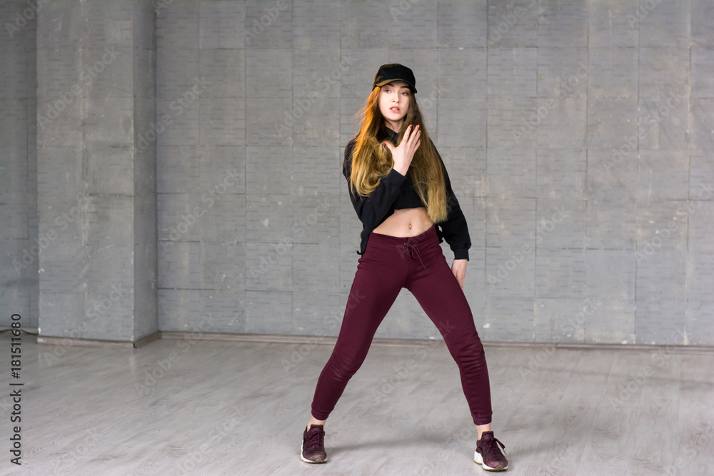 Modern style female dancer. Young woman wearing black cap and sneakers ...