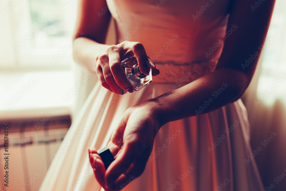 Girl in white expensive dress, spray expensive perfume on his hand ...