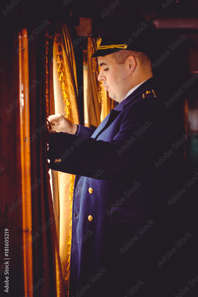 European or American train conductor is on his duty on a platform and ...