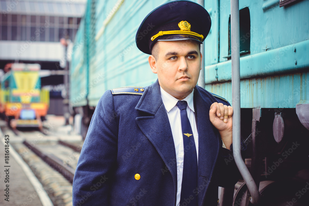 European or American train conductor is on his duty on a platform and ...