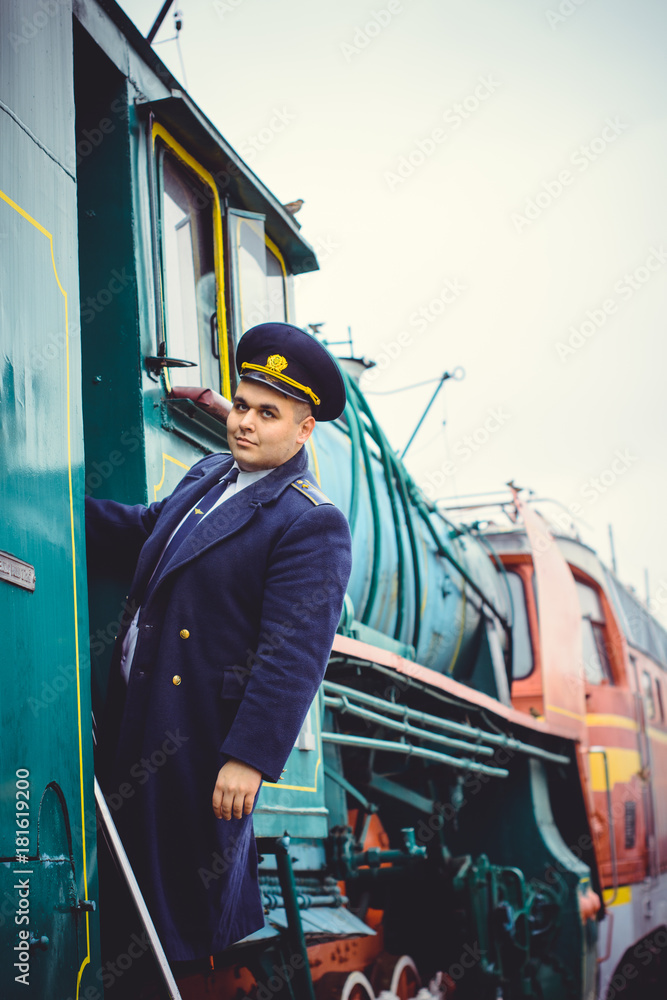 European or American train conductor is on his duty on a platform and ...