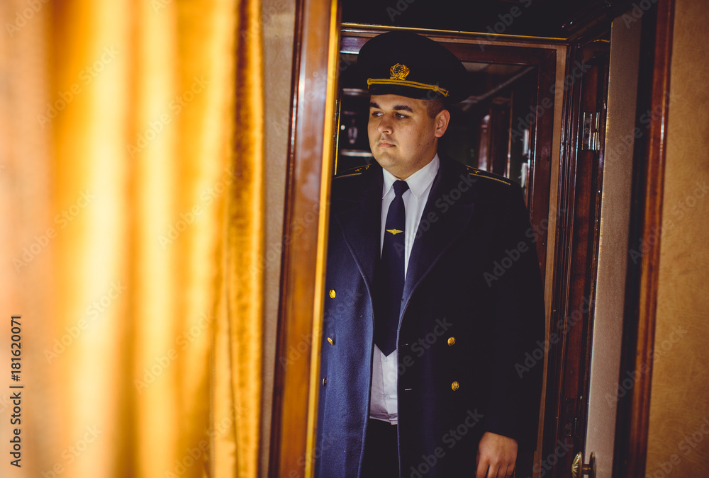 European or American train conductor is on his duty on a platform and ...