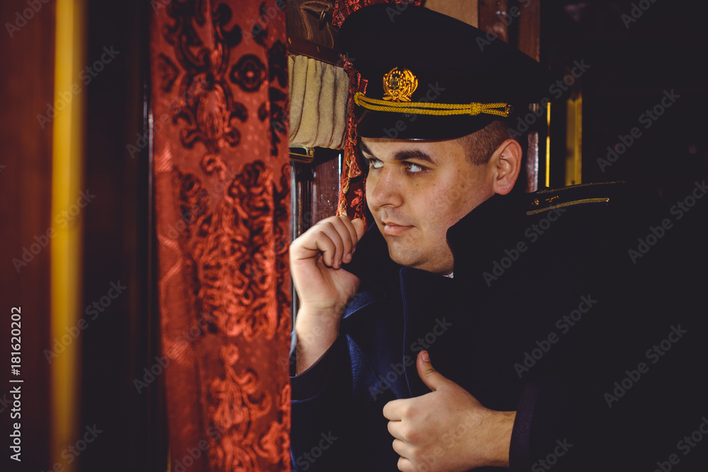 European or American train conductor is on his duty on a platform and ...