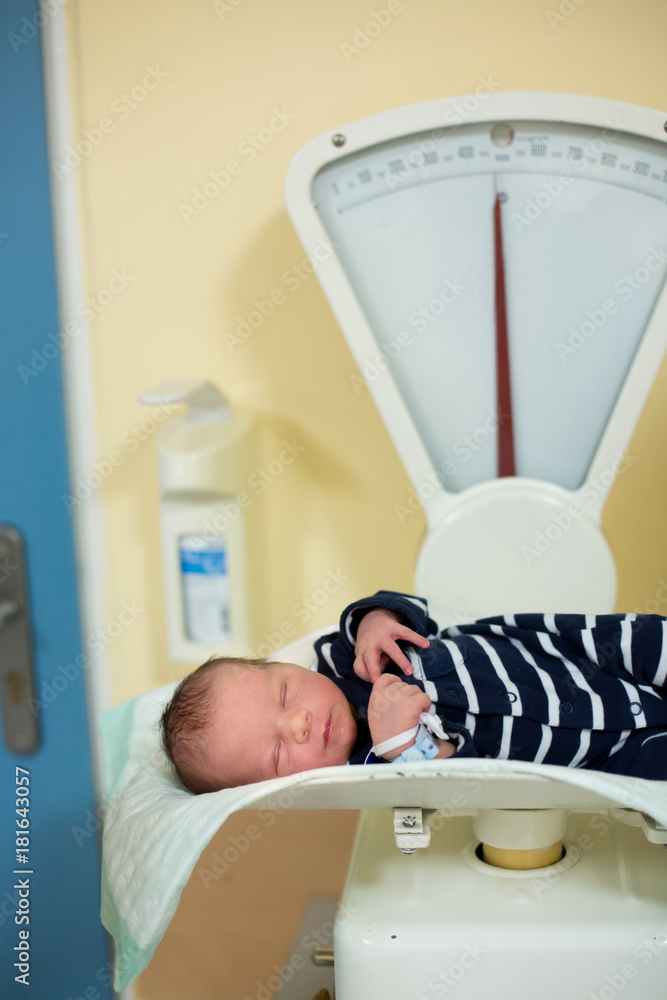 Newborn child after birth in hospital. Adorable cute baby on scale for ...