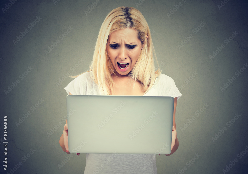 Shocked woman looking at laptop computer anxious with open mouth. Human ...
