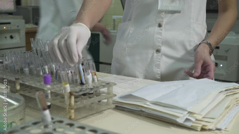 Female laboratory technician examining documentation with patients ...