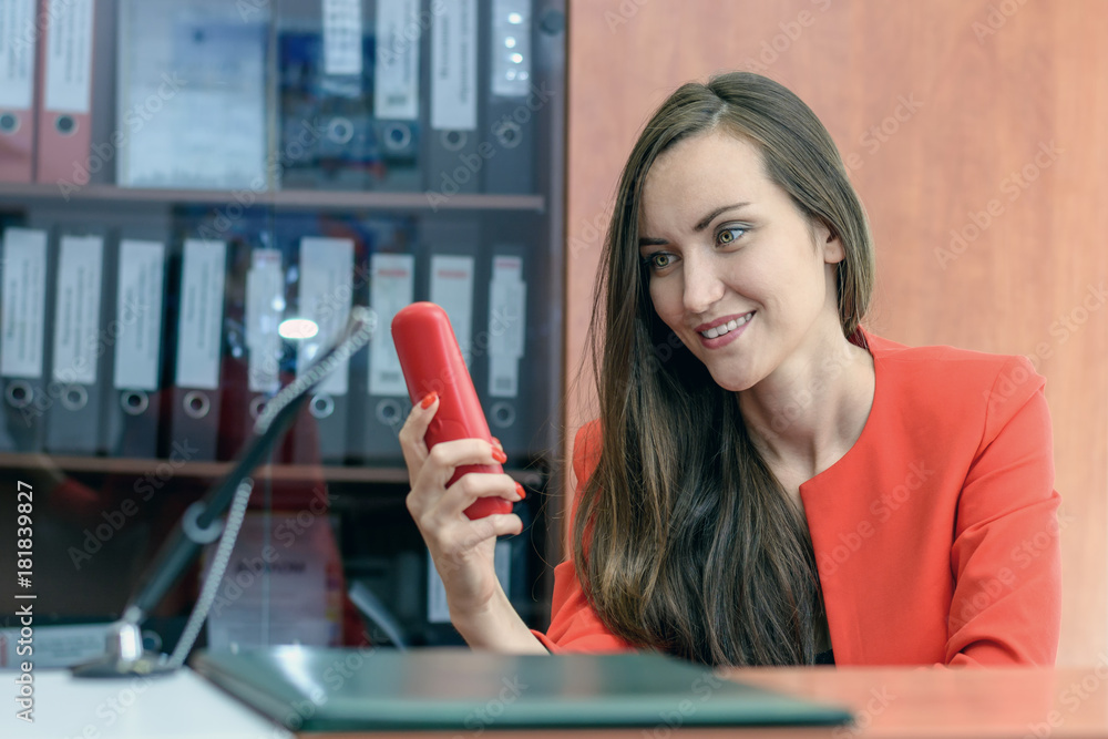 Beautiful woman with long dark hair in a red suit calling on the phone ...