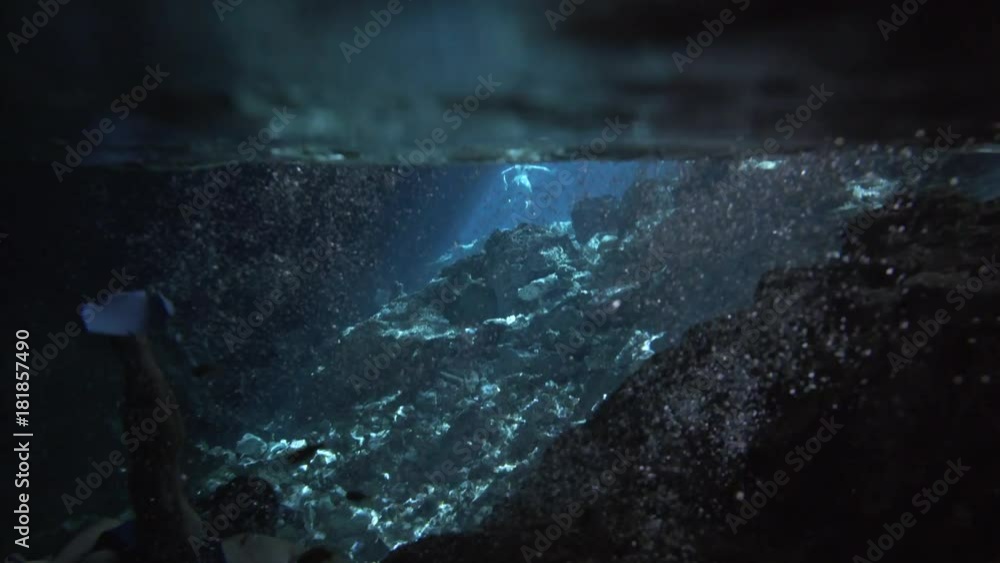 half underwater shot, man in swimsuit with fins dive from camera in ...