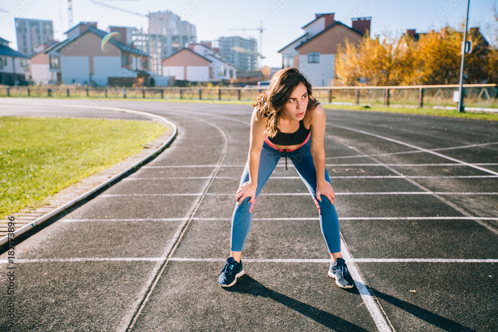 Exhausted young woman jogger catching her breath after a long run on ...
