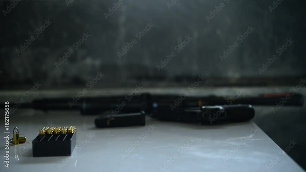 Asian male wearing black leather gloves with gun in hand,loading ...