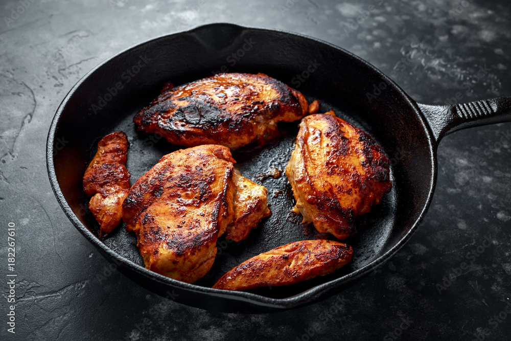 Cooked chicken fillets, breast supremes in rustic cast iron skillet ...
