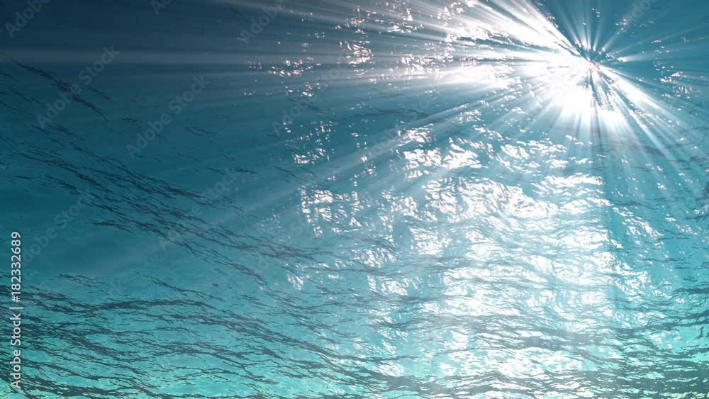 Rays of light make their way through ocean waves from underwater ...