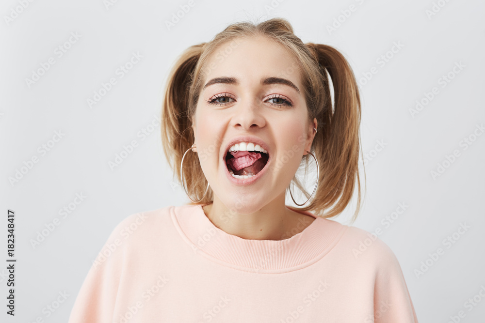 Indoor shot of cute funny positive caucasian female with two ponytails ...