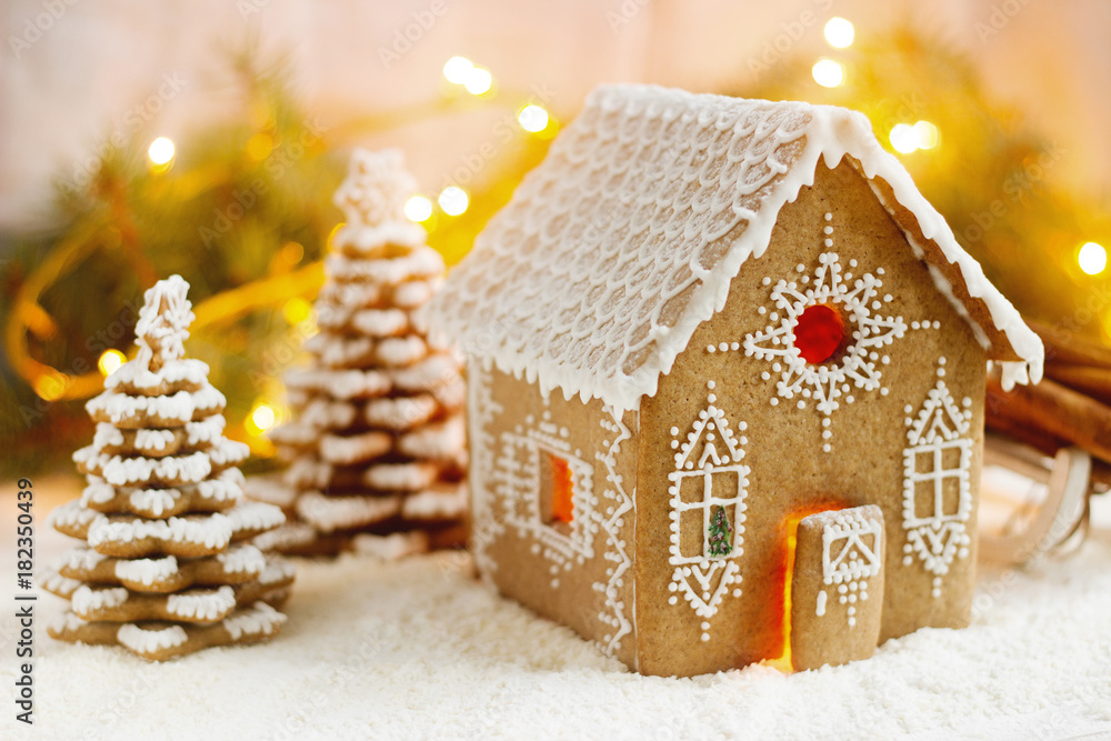 Gingerbread house and Christmas trees on a luminous background. Bokeh ...