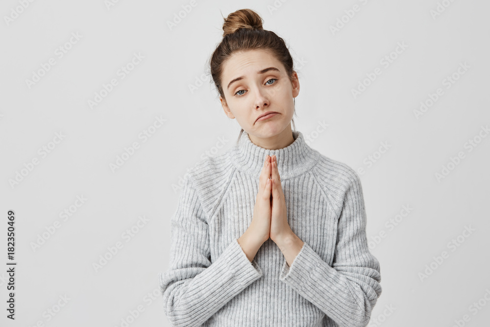 Sad facial expressions of pretty lady with hands together for ...